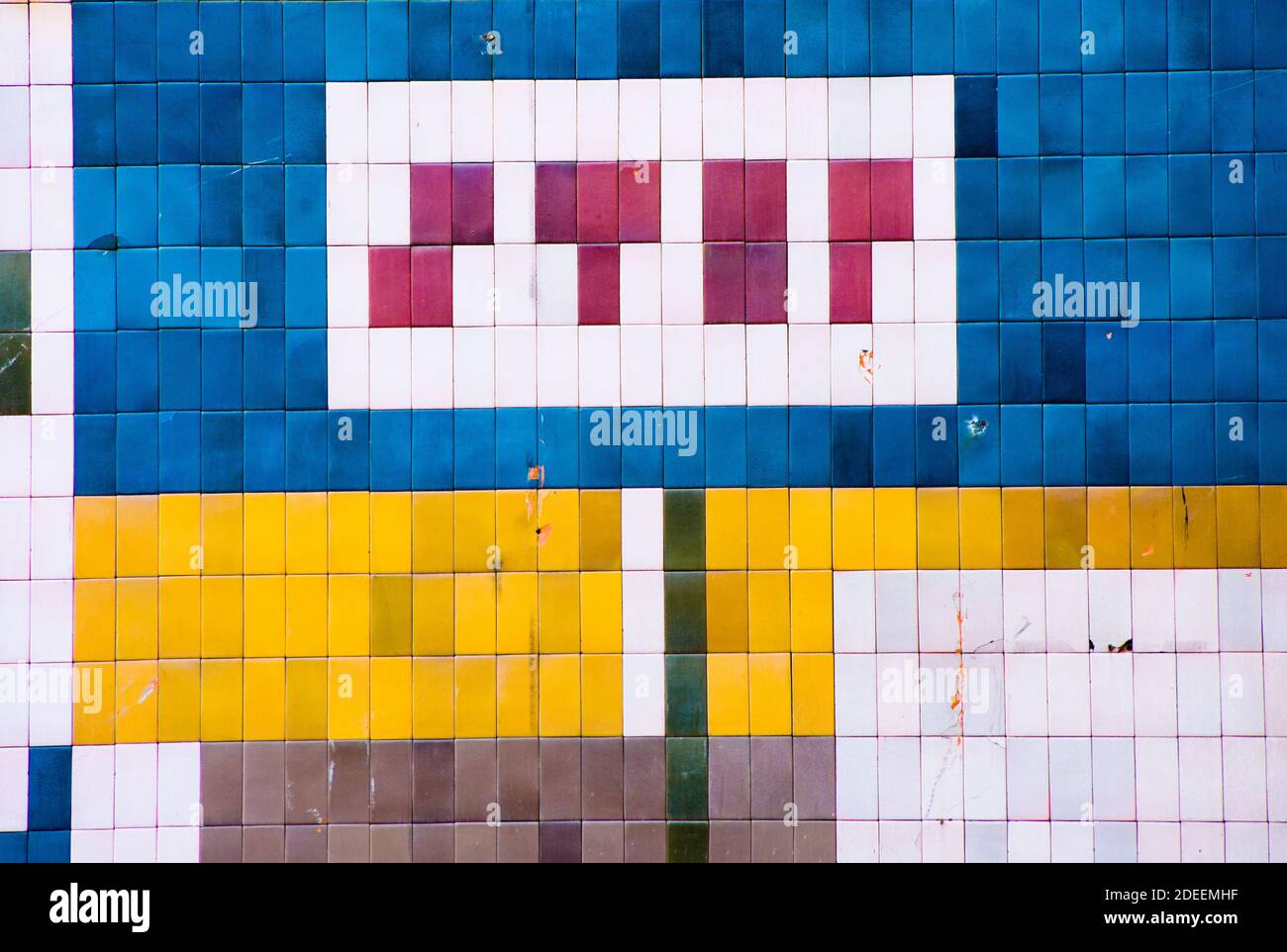 Stop word in red tiles. Wall covered of colored tiles in blue, yellow ...