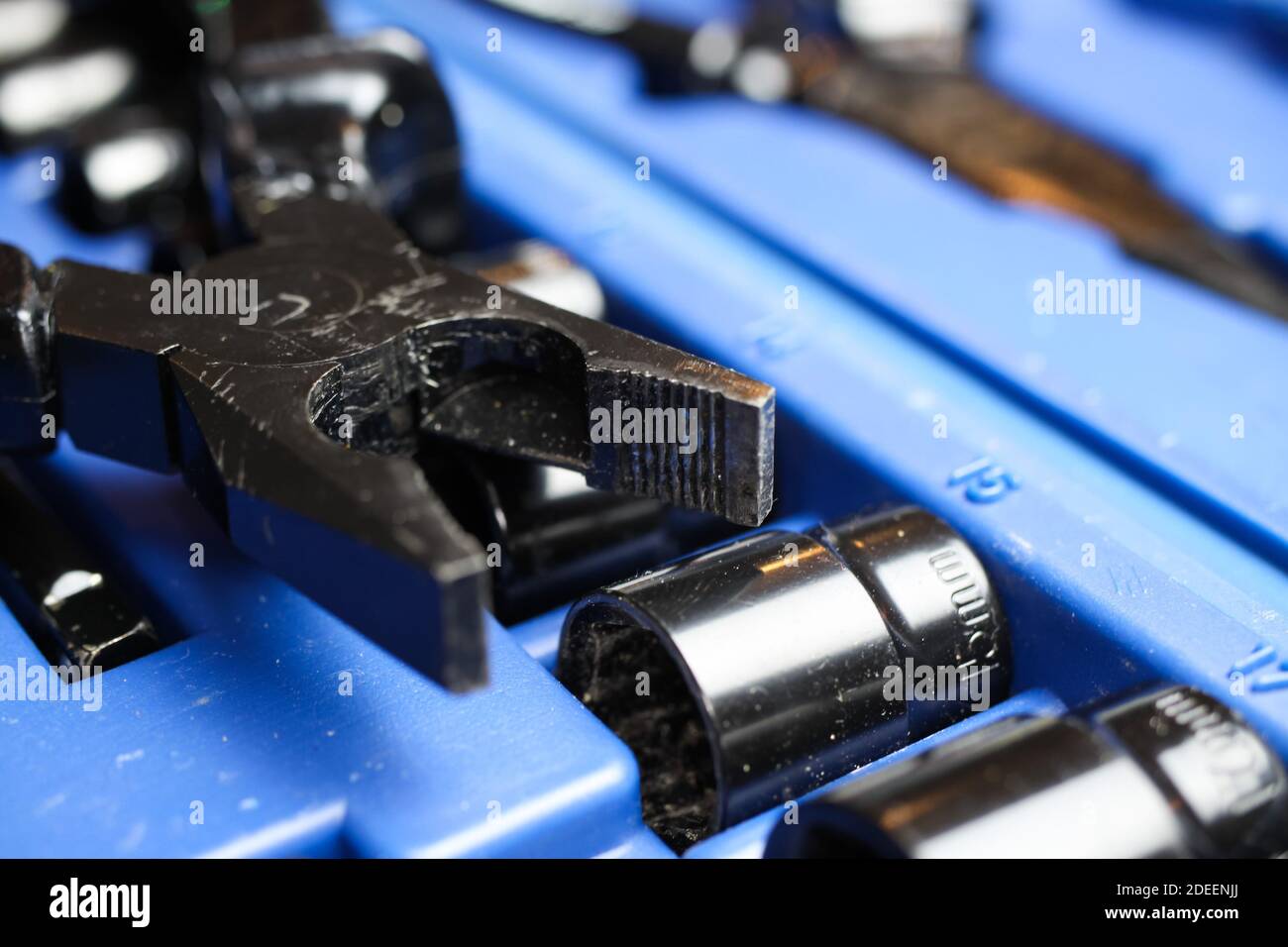 Macro close up of black isolated pliers on blue socket tool set box ...