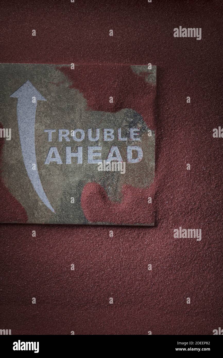 Trouble ahead tile in red sand Stock Photo - Alamy