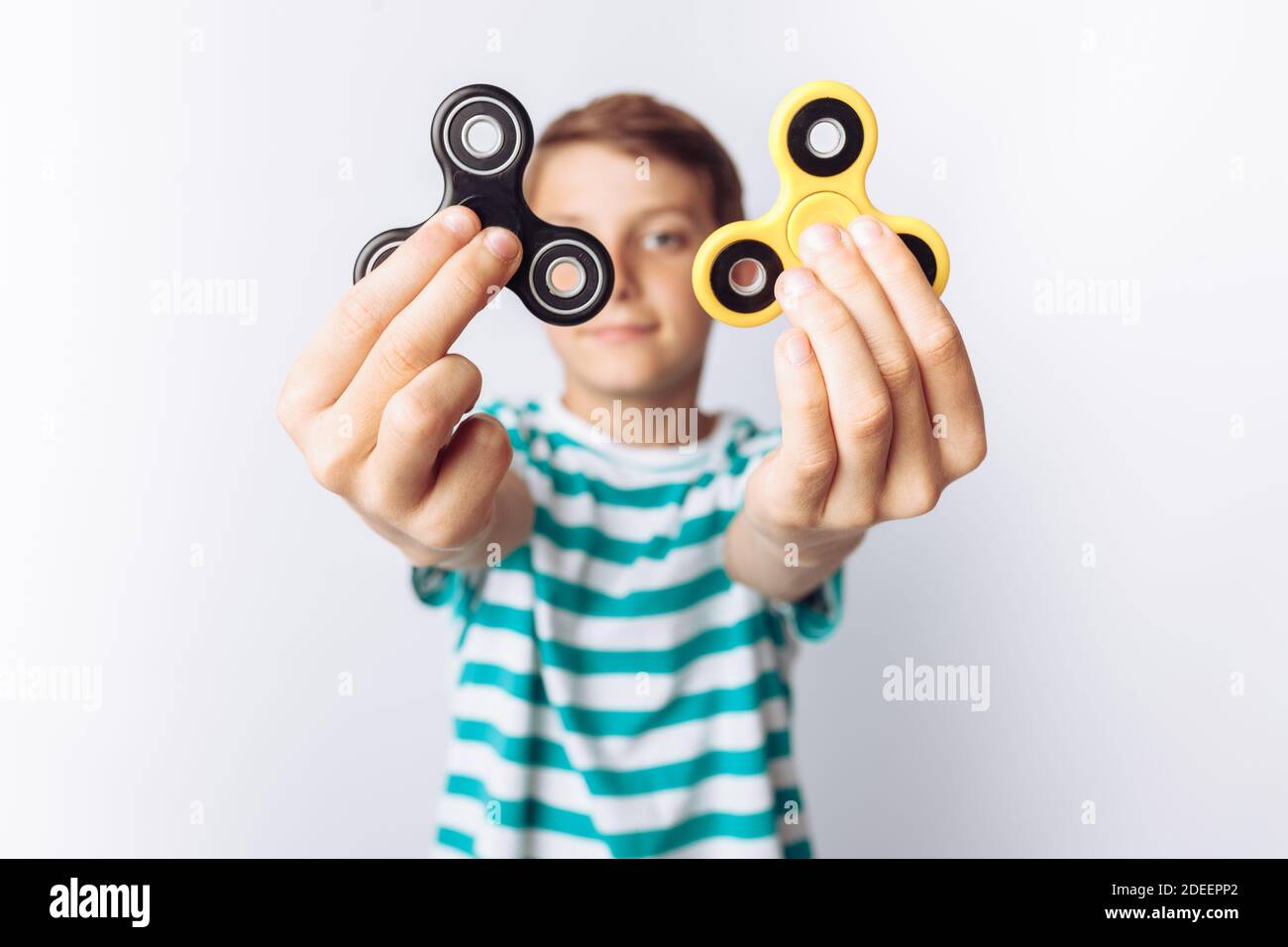 Portrait of a beautiful and emotional boy, holding spinners, plays ...