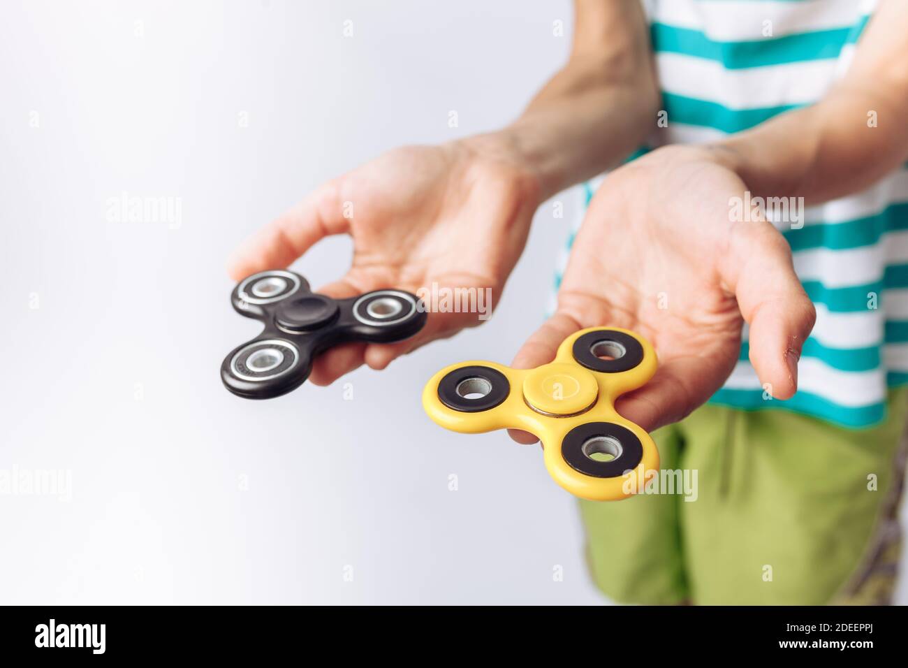 Portrait of a beautiful and emotional boy, holding spinners, plays ...