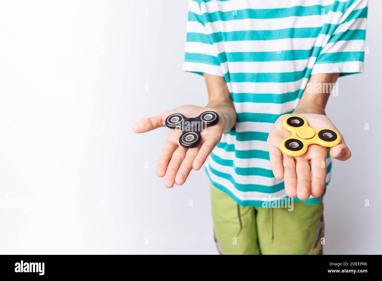 Portrait of a beautiful and emotional boy, holding spinners, plays ...