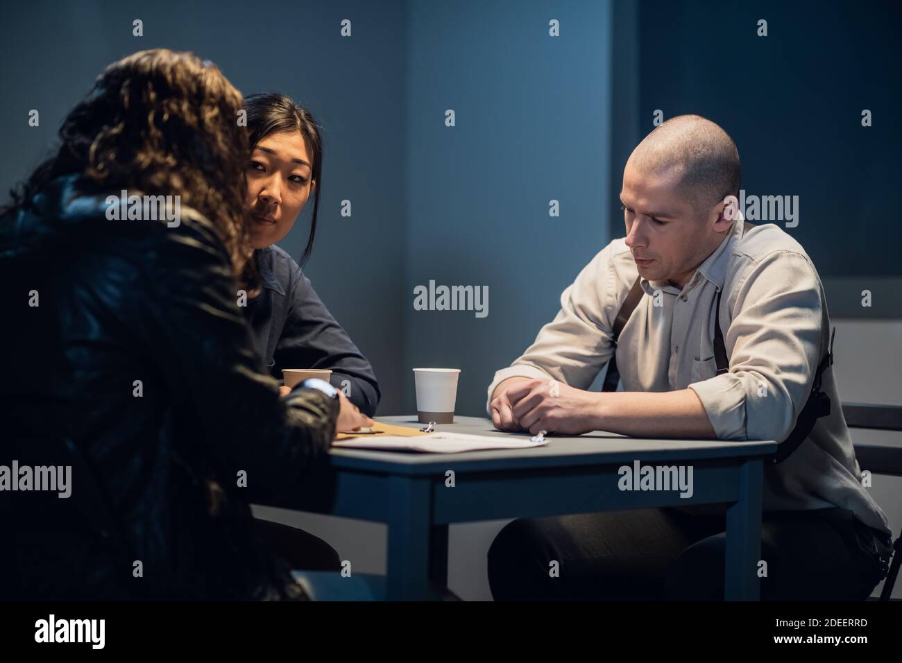 In the interrogation room, the investigator and the officer are talking ...