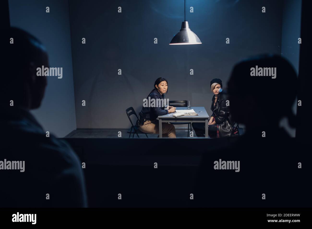 A detective and a witness watch through Gesell mirror as a young ...