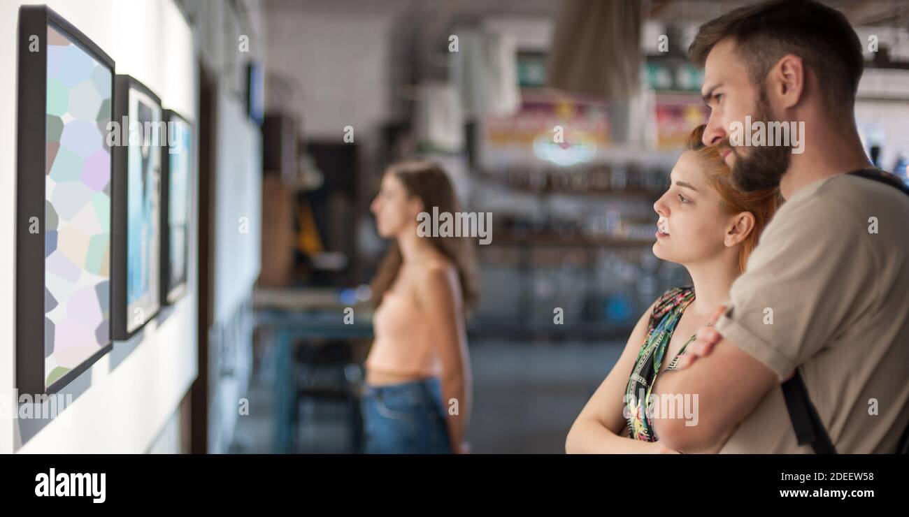Group of friends in modern art exhibition gallery hall contemplating ...