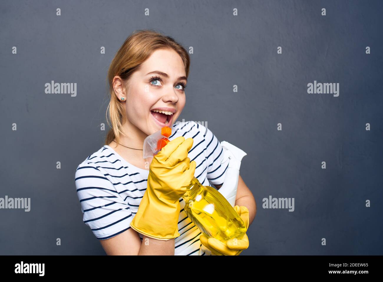 Cheerful cleaning lady with detergent in hands cropped view of gray ...
