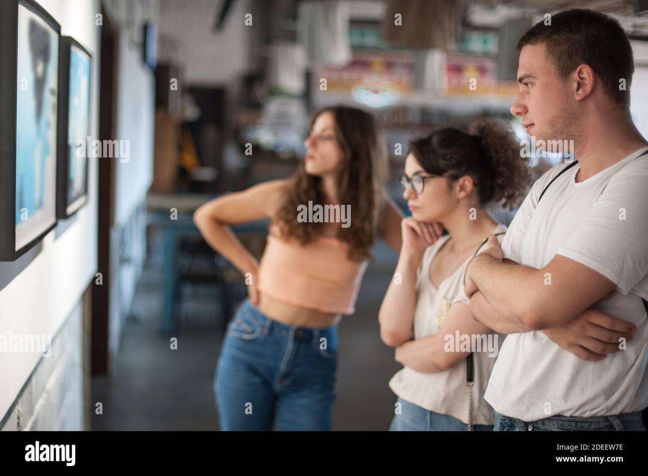 Group of friends in modern art exhibition gallery hall contemplating ...