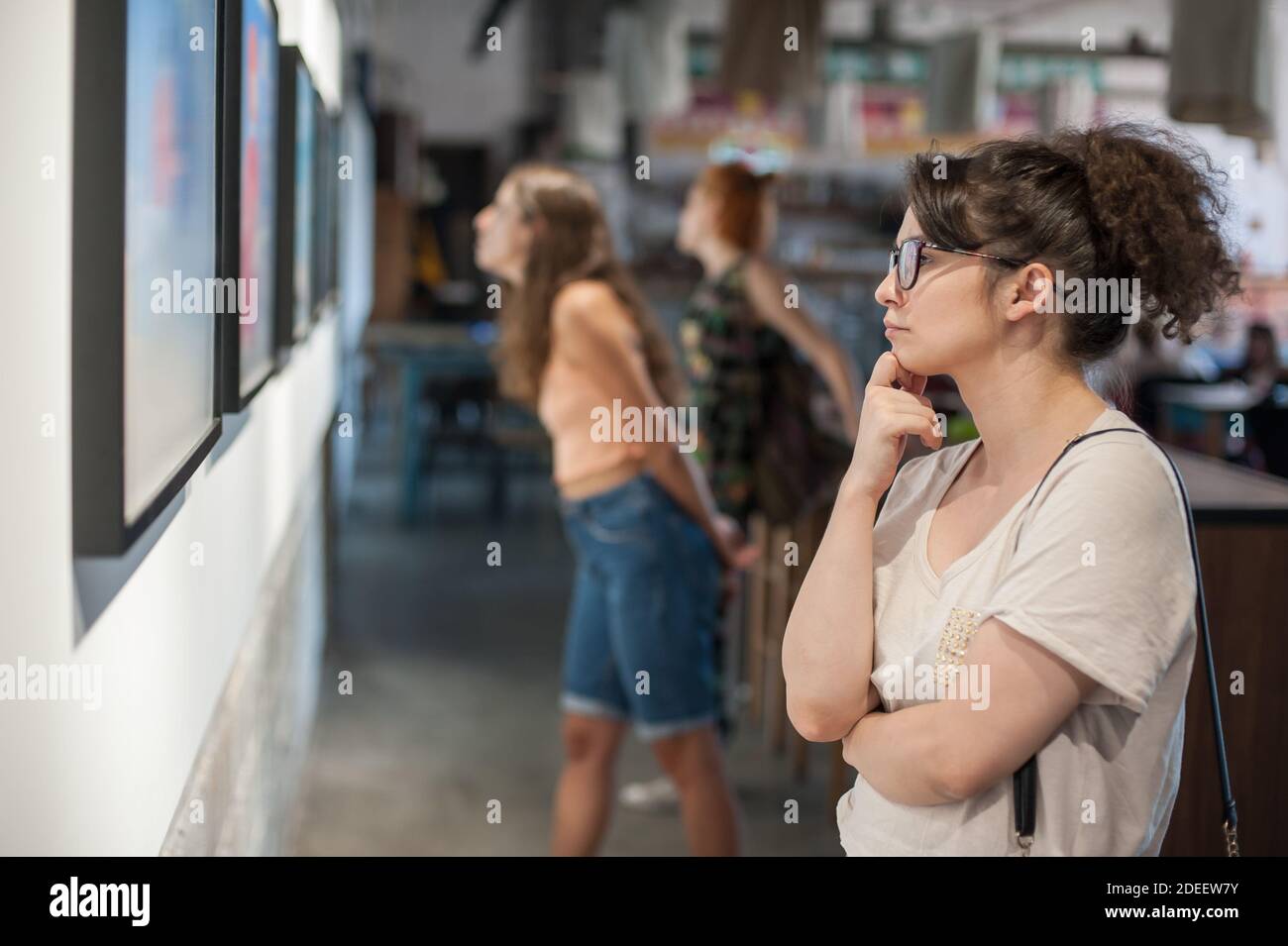 Group of friends in modern art exhibition gallery hall contemplating ...