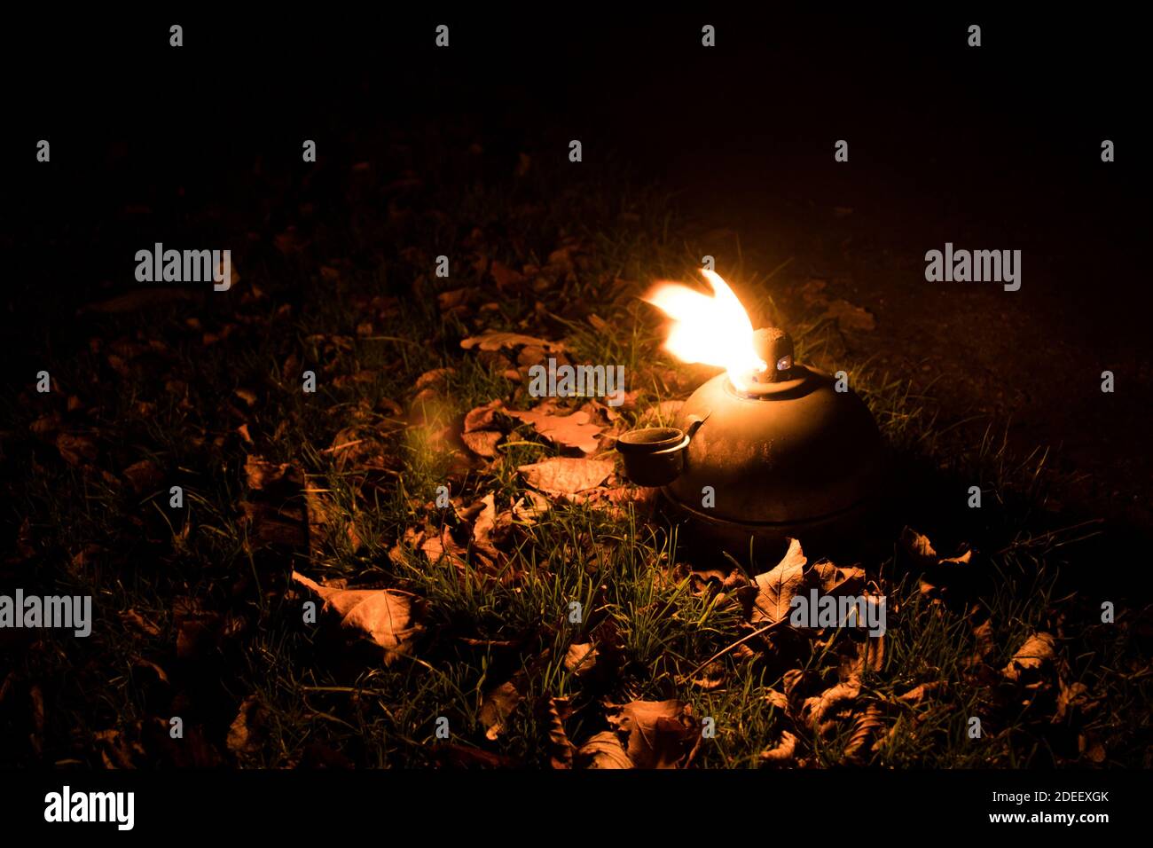 An oil lamp flaming and burning during the night in the grass ...