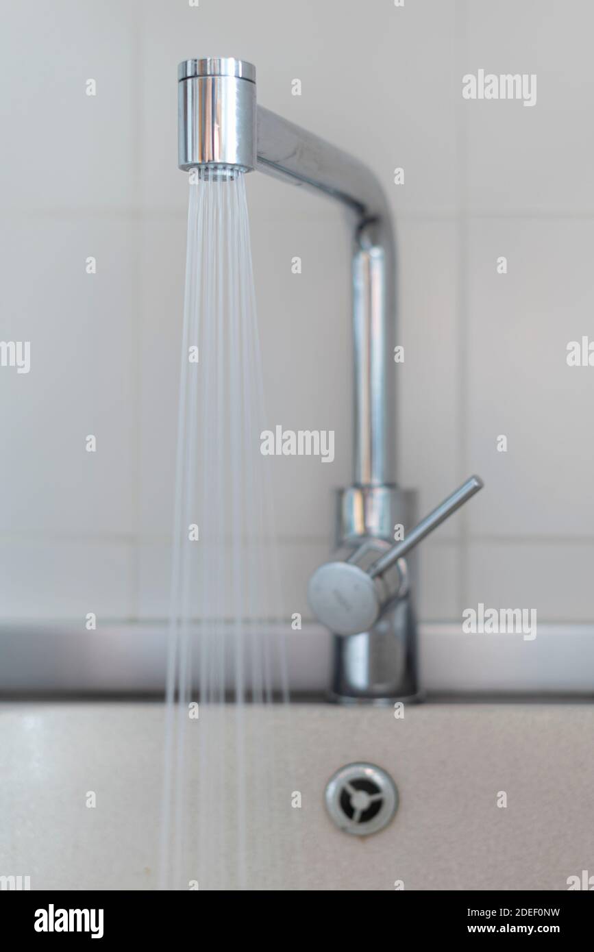 Water tap open uselessly, wasting water Stock Photo - Alamy