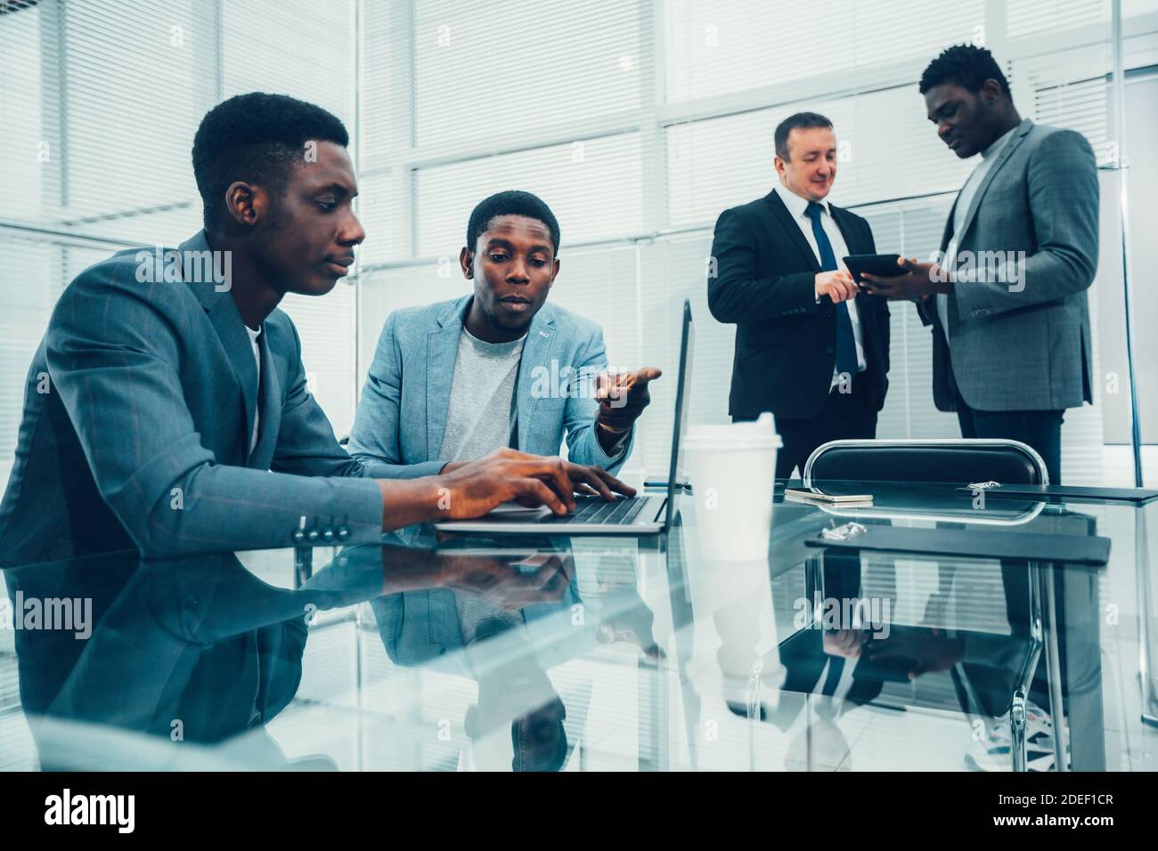 Employees discussing in office typing hi-res stock photography and ...
