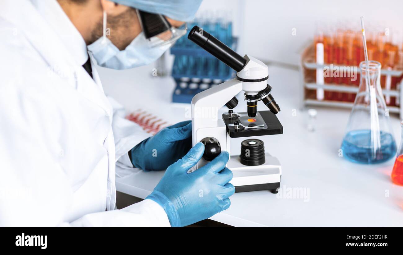 scientist looking at a drop of blood through a microscope Stock Photo ...