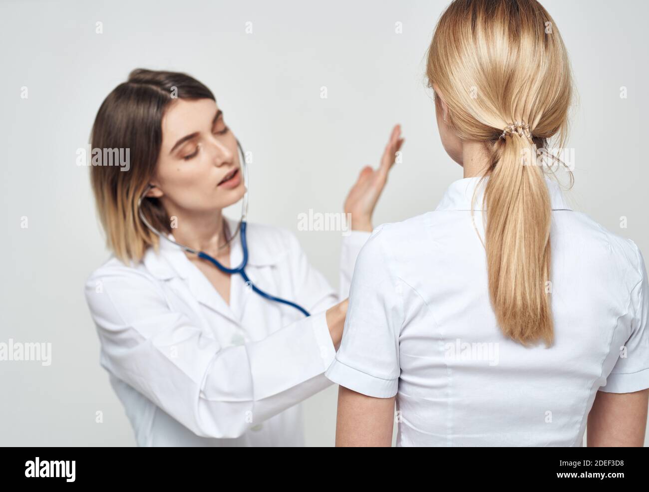 doctor woman in a medical gown with a stethoscope communicates with a ...