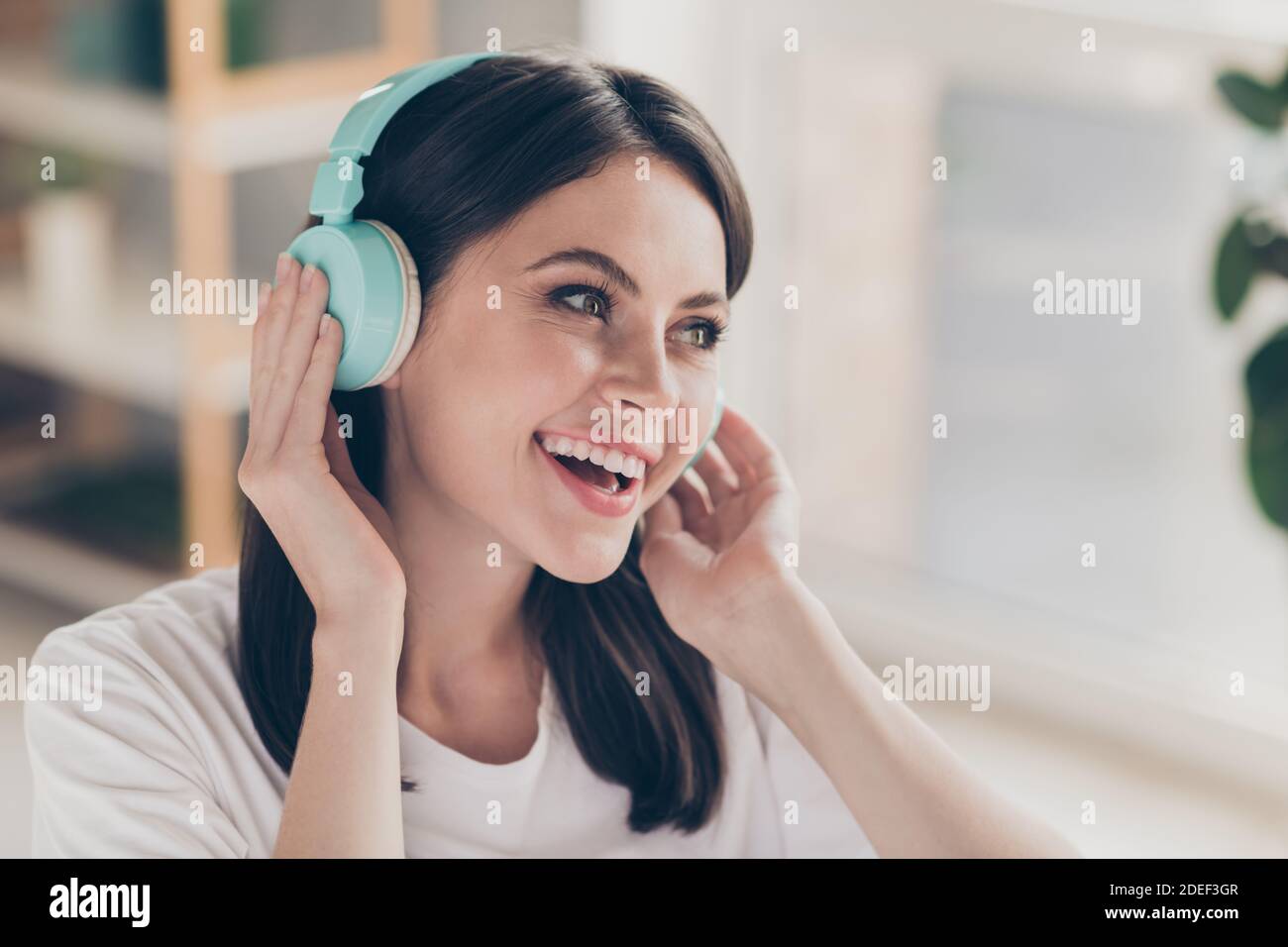 Photo of cheerful youngster girl listen stereo song with wireless blue ...