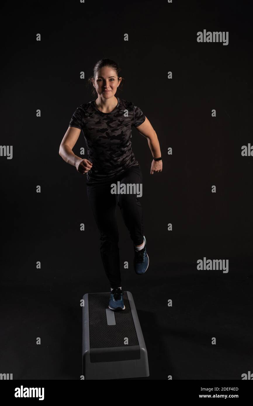Fitness on a step platform, doing exercises. Is engaged in sports on a ...