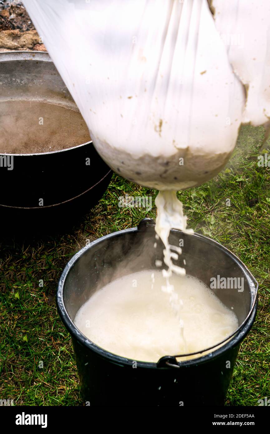 Homemade cheese production in a large cauldron over a fire Stock Photo ...