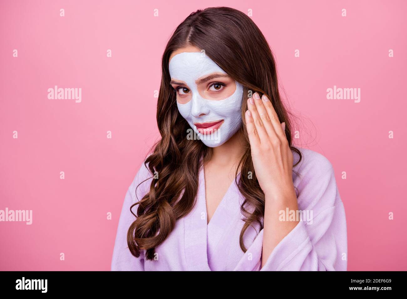 Photo portrait of shy pretty tender girl applies skincare facial mask ...