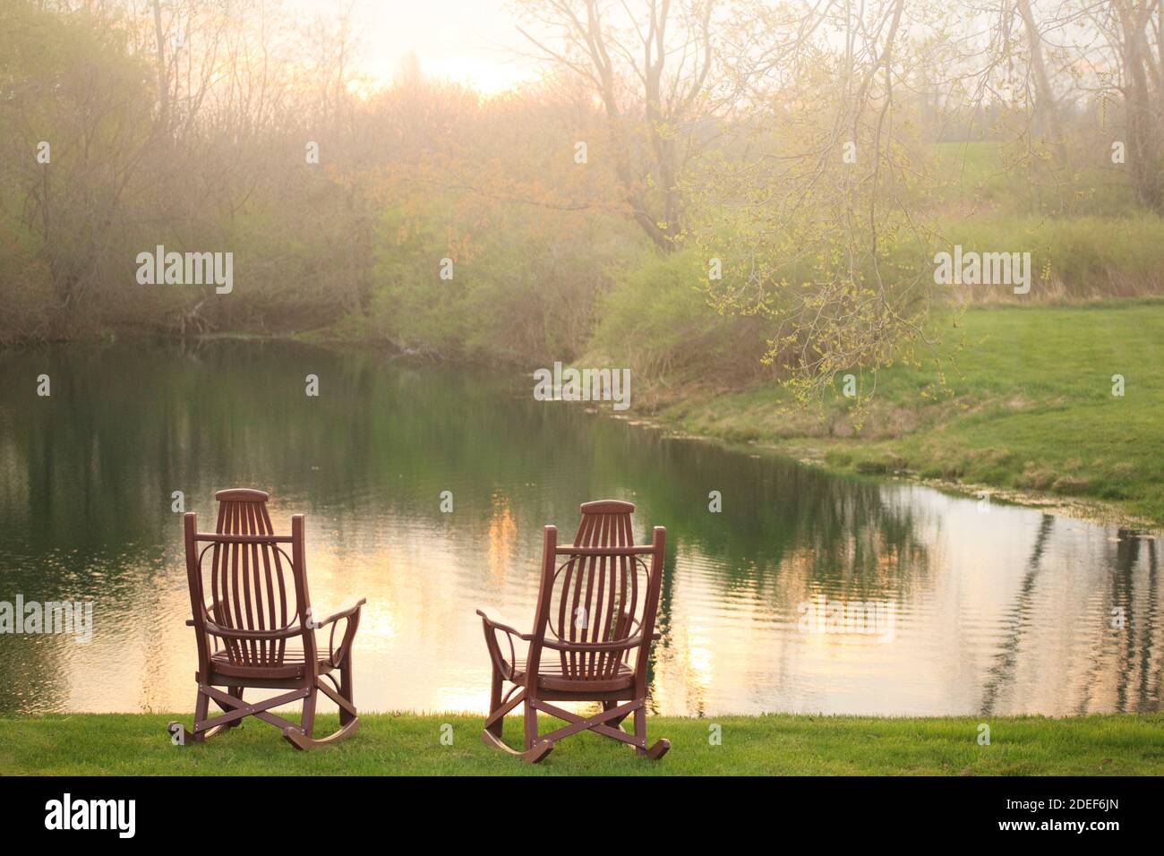 Chairs by a pond in early morning Stock Photo - Alamy