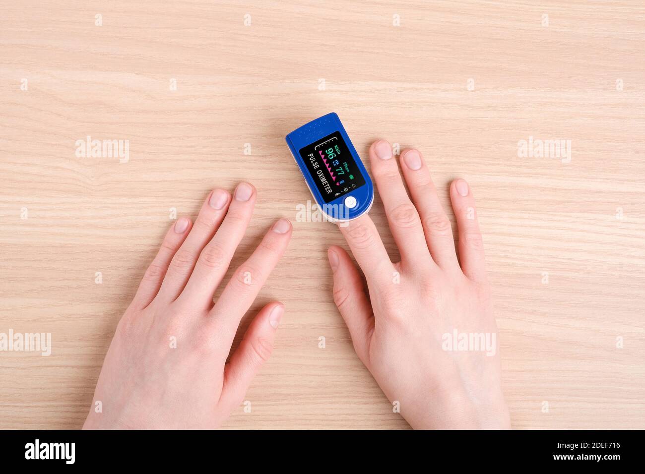 Person using pulse oximeter device on finger, healthcare monitoring ...