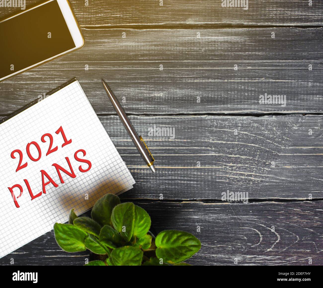 2021 Plans concept. Desktop with notebook, phone, pen. Planning goals ...