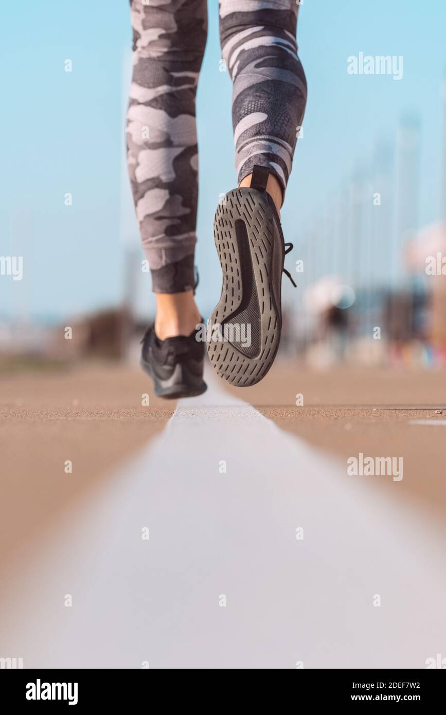 Fit woman athlete running on the road. Runner shoes close up Stock ...