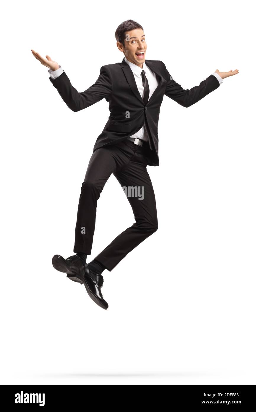 Excited young businessman in suit and tie jumping isolated on white ...