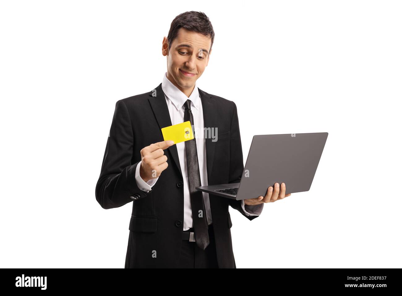 Man in a suit with credit card and a laptop computer isolated on white ...
