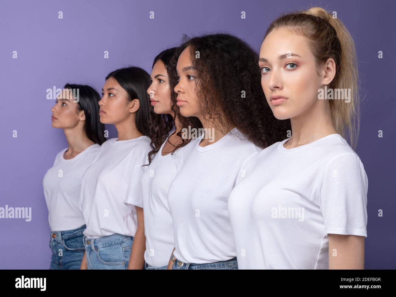 Group Of Serious Multicultural Women Standing In Row, Purple Background ...