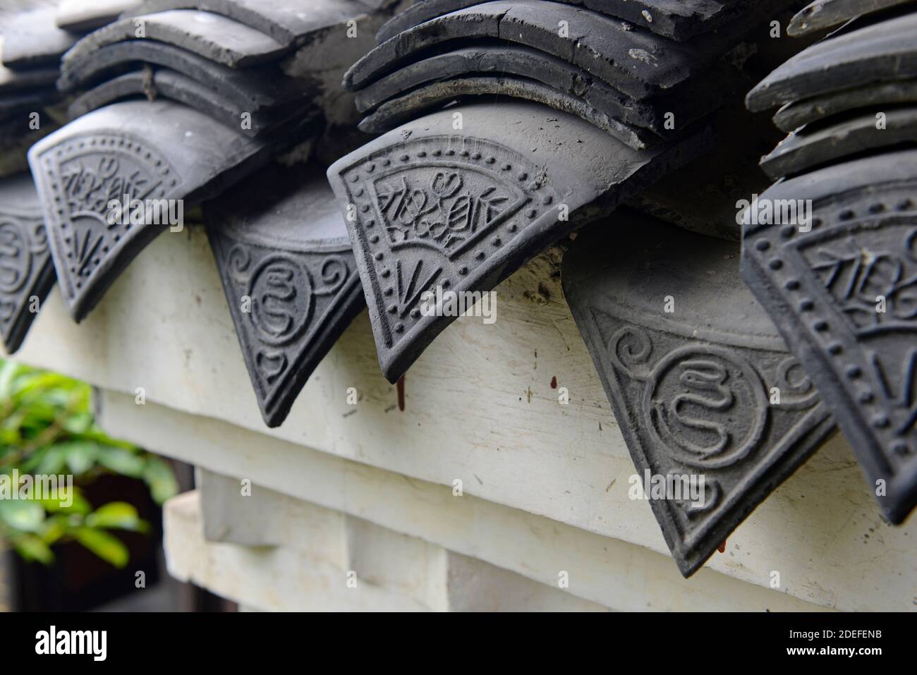 Decorated end of row tiles on a roof in Qingyan ancient town near ...
