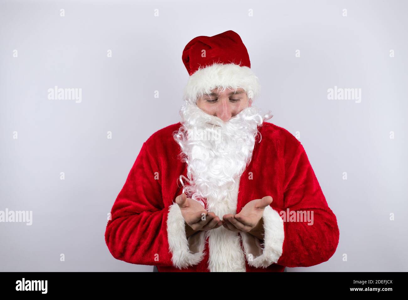 Man dressed as Santa Claus standing over isolated white background ...