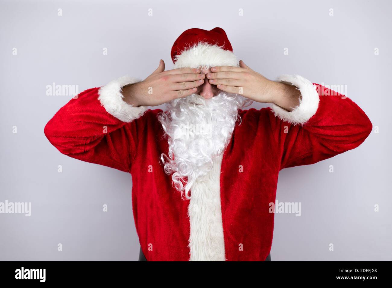 Man dressed as Santa Claus standing over isolated white background ...