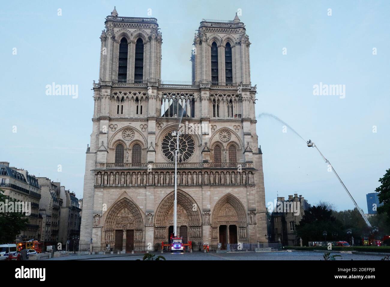Paris Fire brigade members spray water onto the facade of the Notre ...