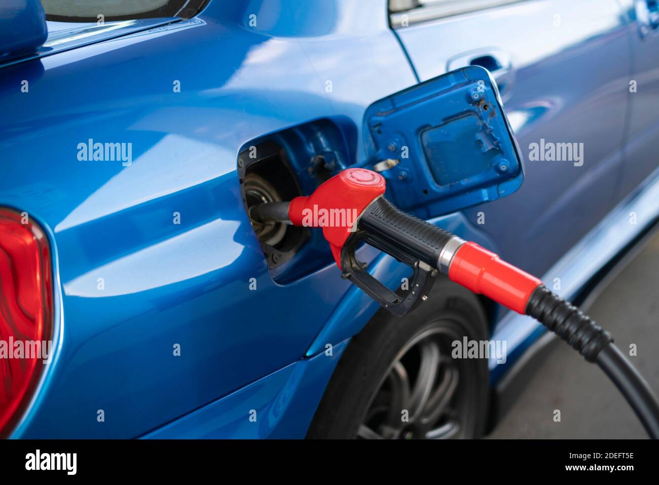 fuel pump inserted in the sport car on the fuel station, pour gasoline ...