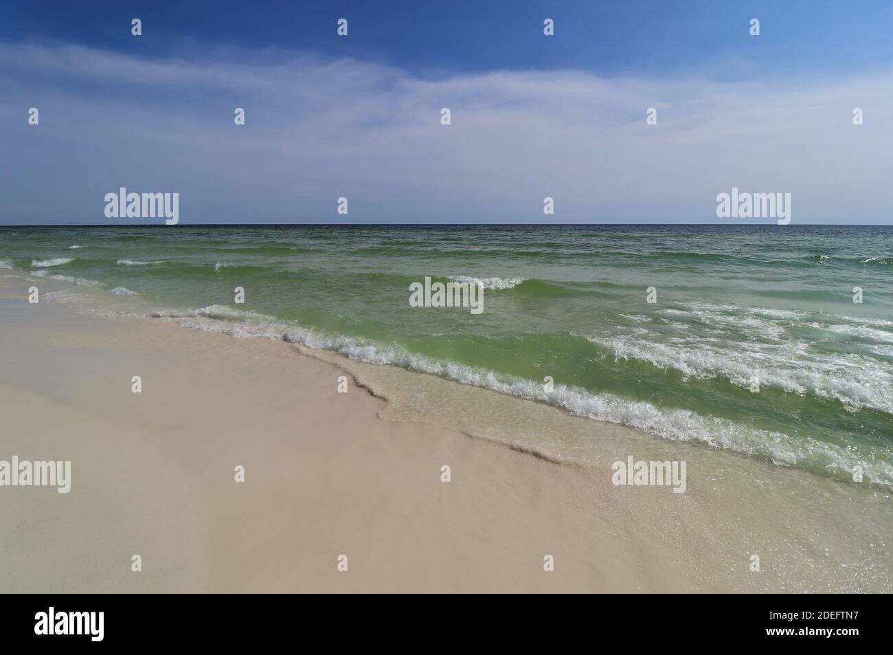 Close-up green wave on the ocean shore, small wave creates foam ...