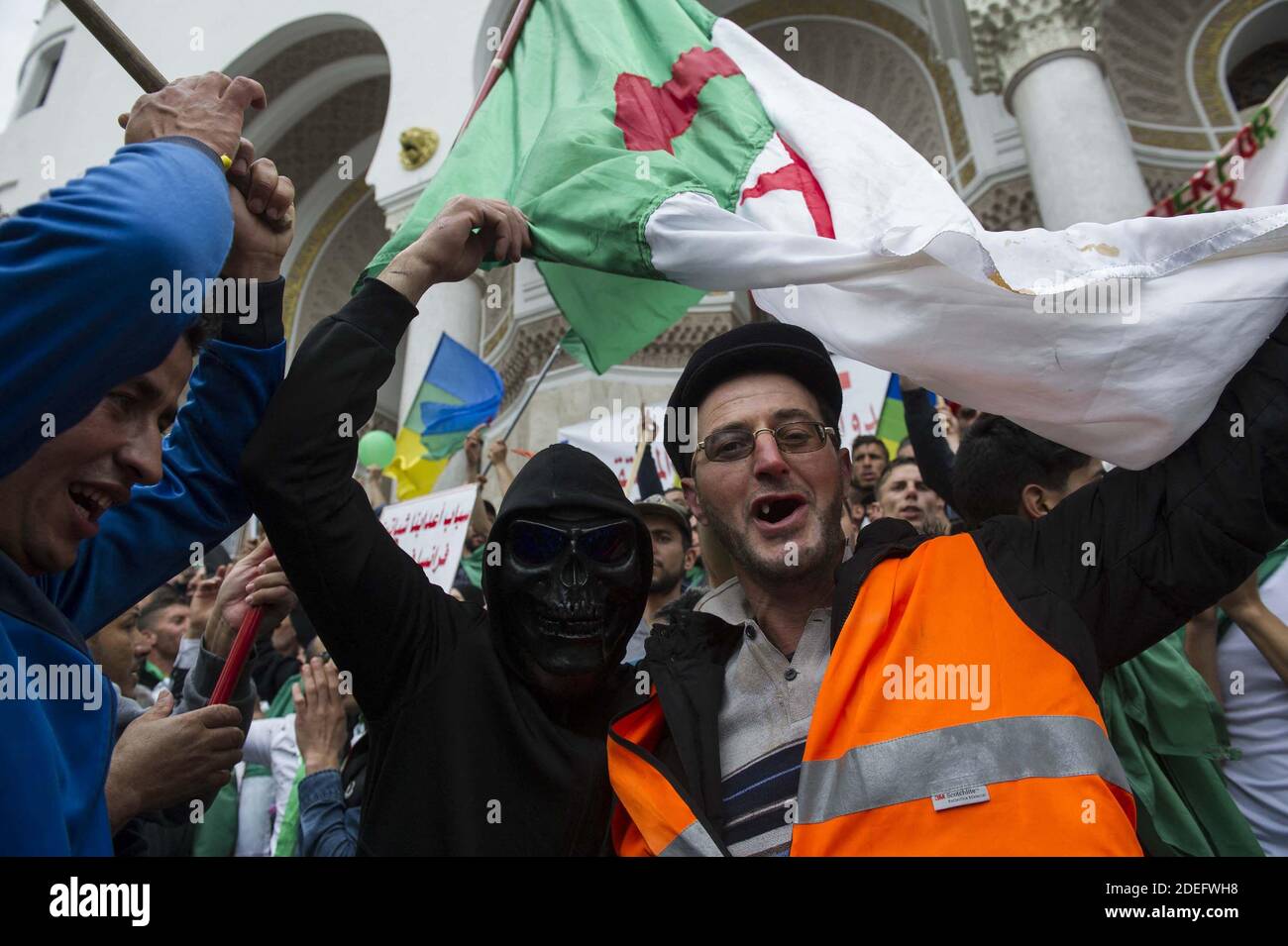Algerians waving national flags and banners, shout slogans in front of ...