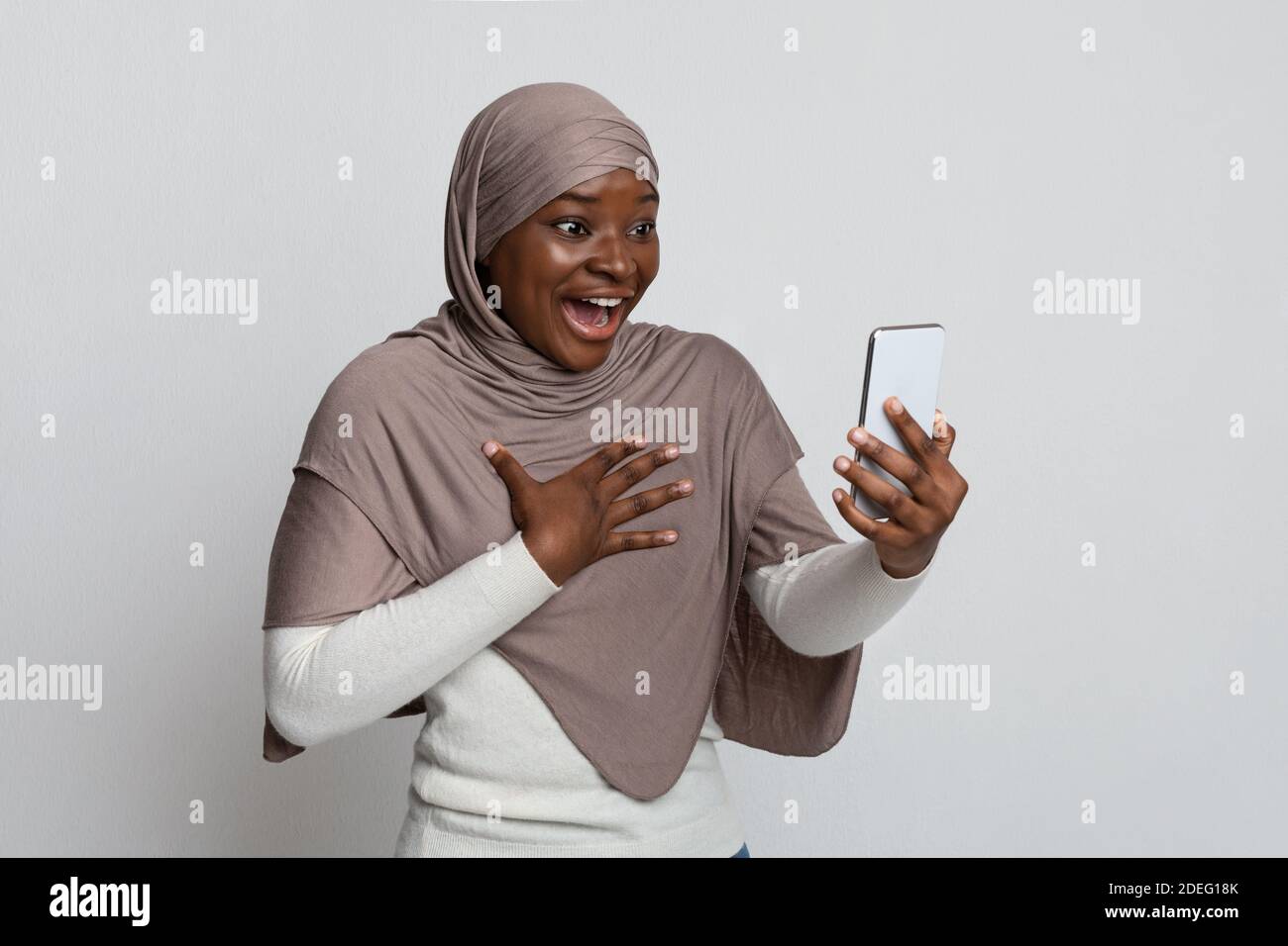 Omg. Shocked Brunette Lady Looking At Smartphone Screen With Surprised ...