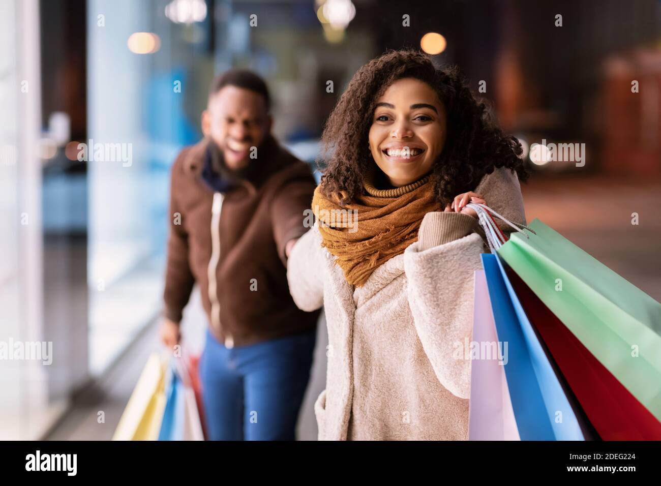 Excited Black Lady Pulling Boyfriend To Shopping Store Stock Photo - Alamy
