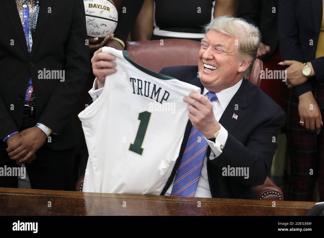 President Donald Trump holds a basketball jersey with his name on it ...
