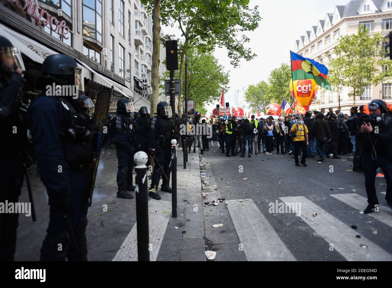 Police officers wait while people walk during the annual may day ...