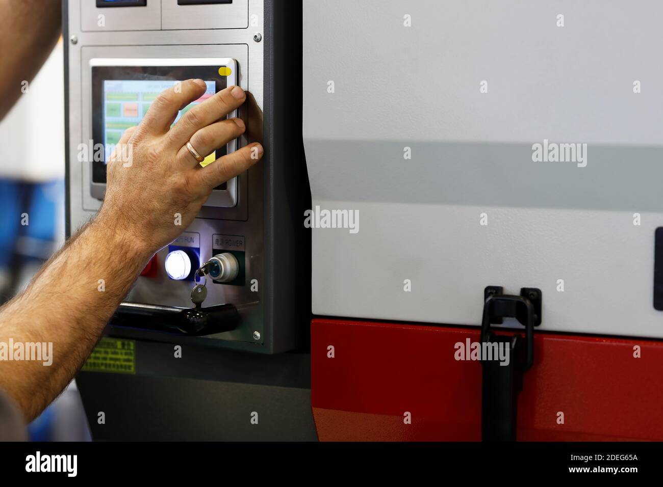 Worker controls the operation of modern equipment using a touch screen ...