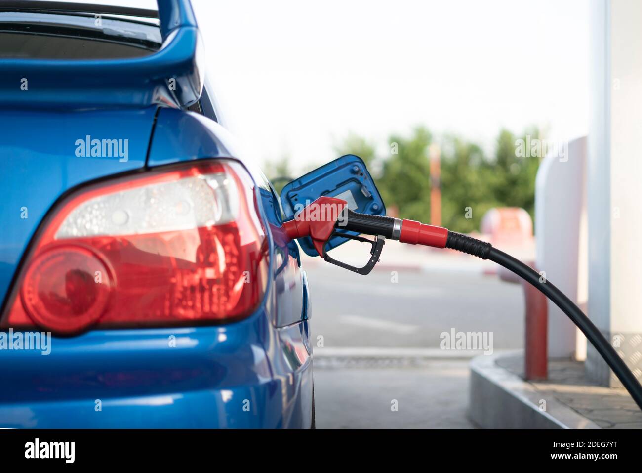 a fuel pump inserted in the sport car on the fuel station, pour ...