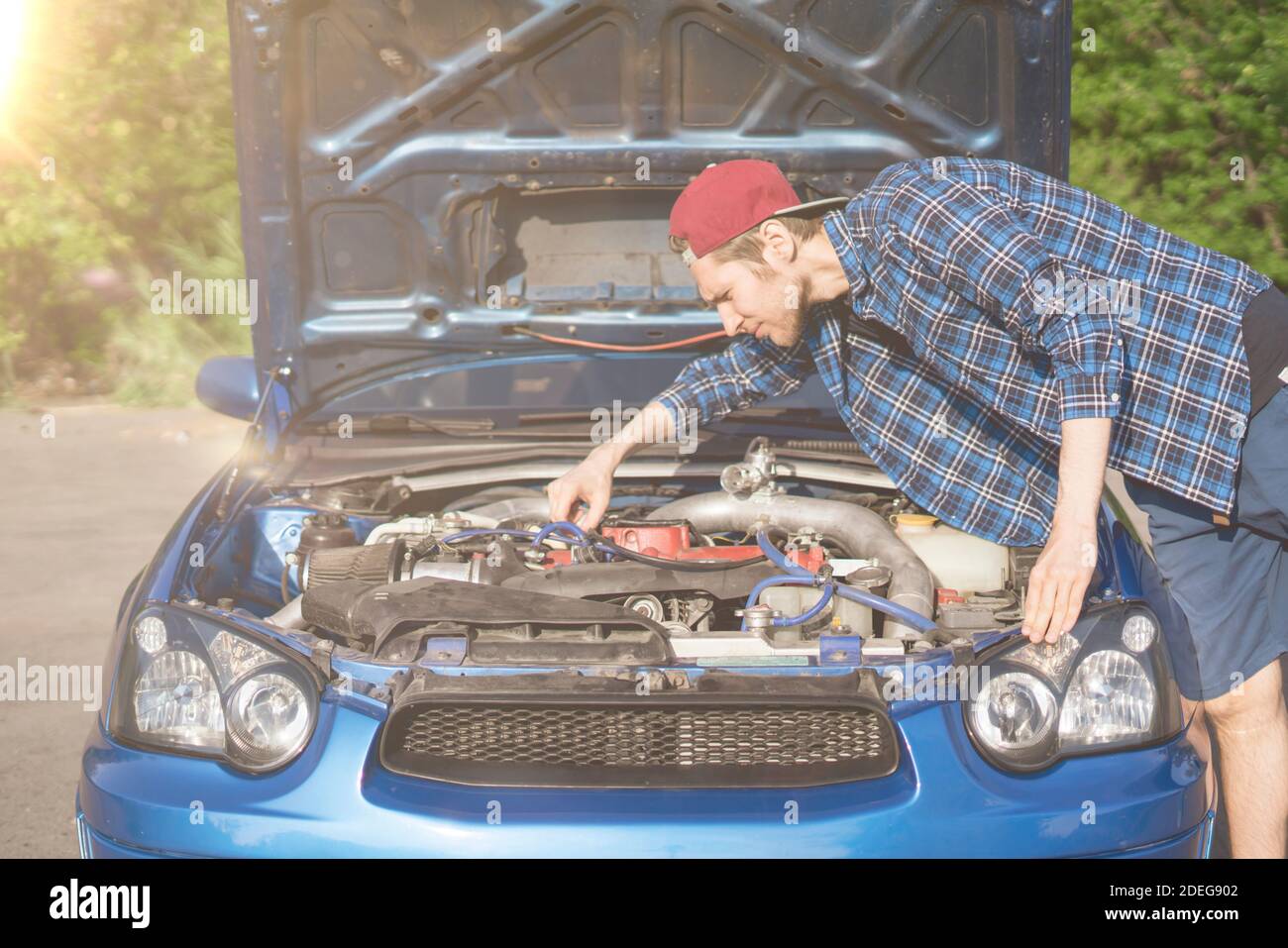 the sad disappointed man standing near the car with opened hood, fix ...