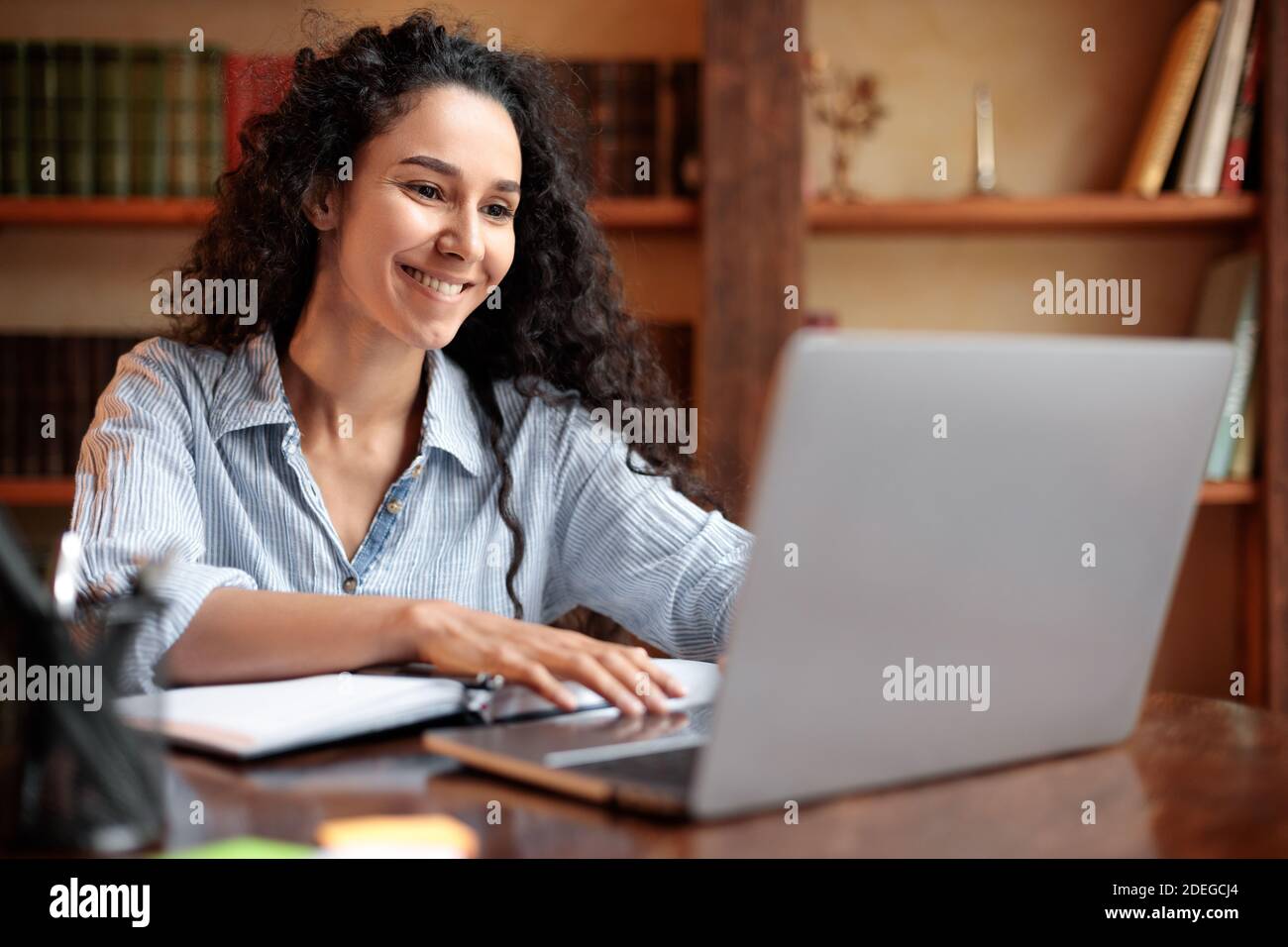 Woman sitting at desk, using computer and typing on keyboard Stock ...