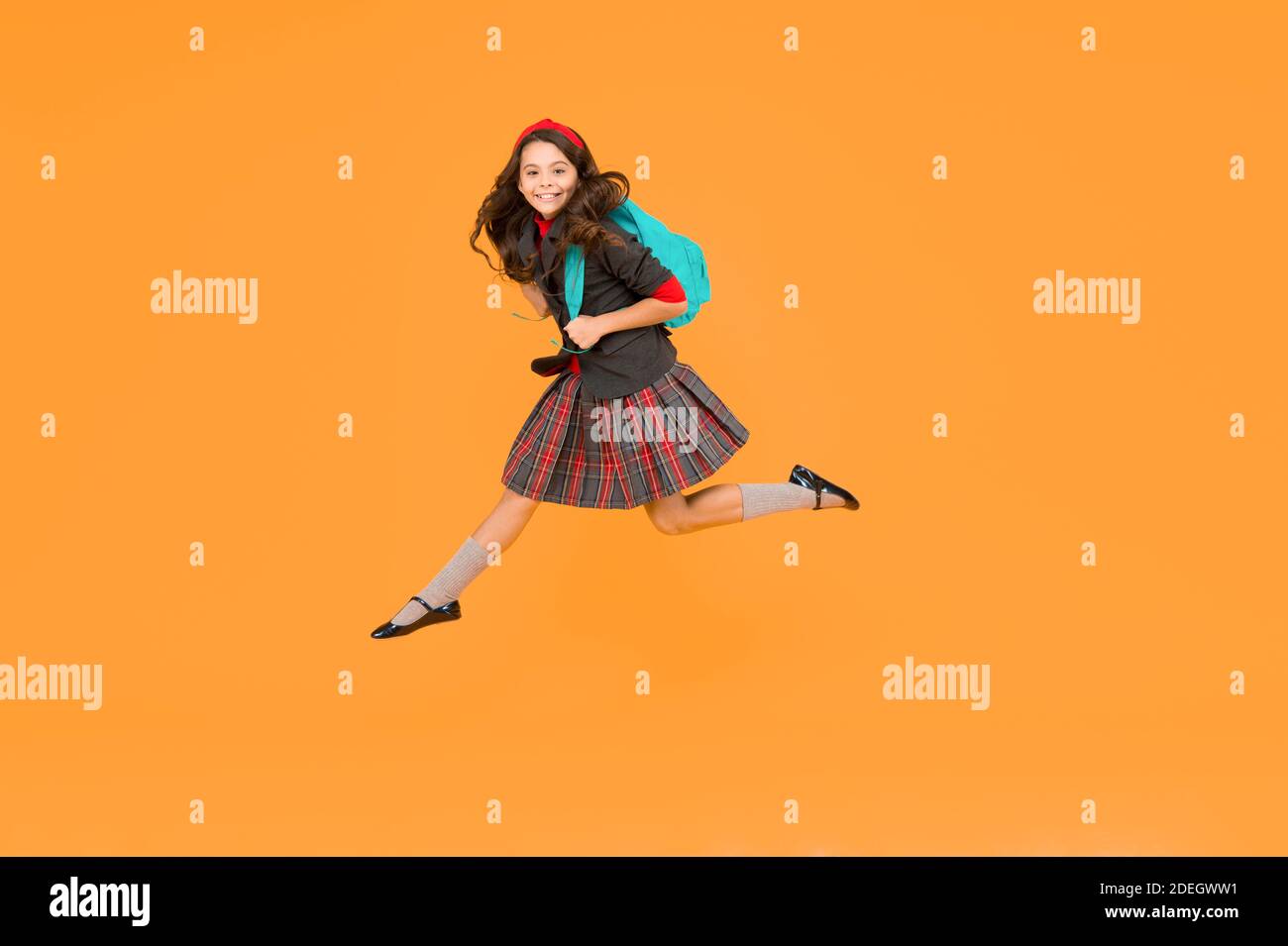 Happy little girl child in uniform hurry to school carrying backpack in ...