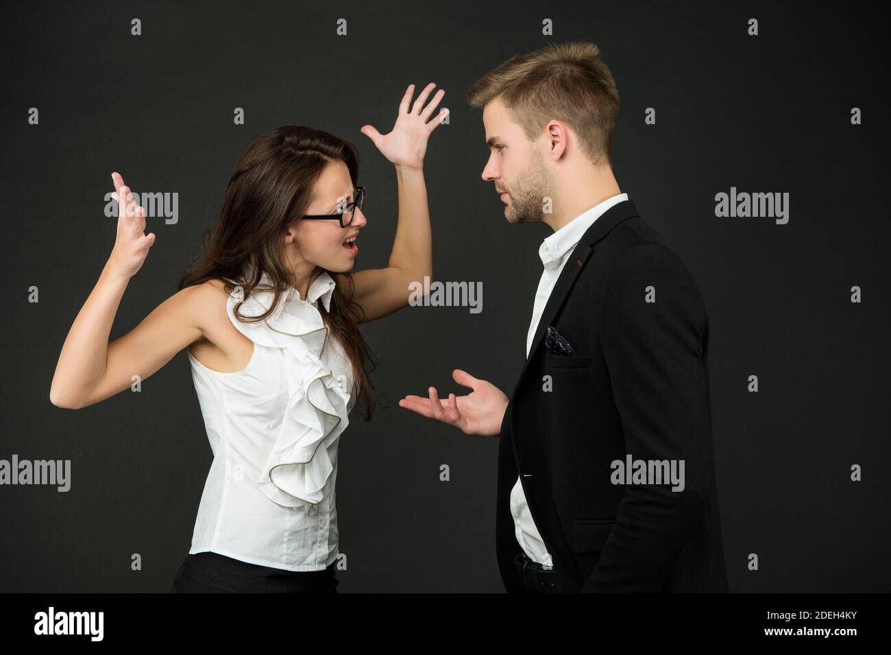 Disagreement among colleagues. Emotional woman and man fight dark ...