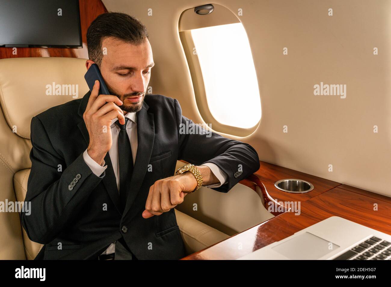 Handsome businessman wearing elegant suit flying on exclusive private ...