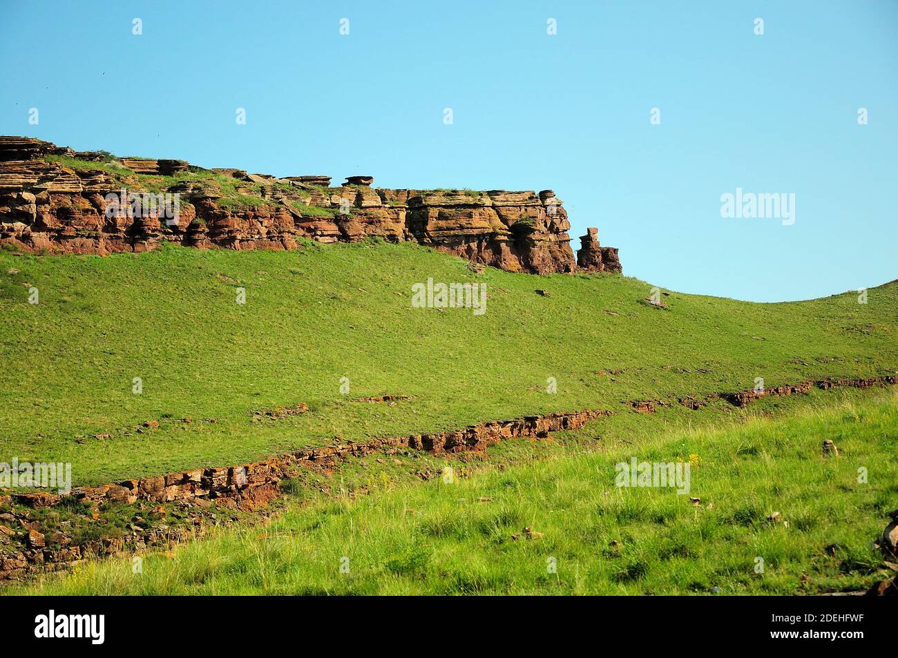 Remains of an ancient red stone wall running along the top of the hill ...