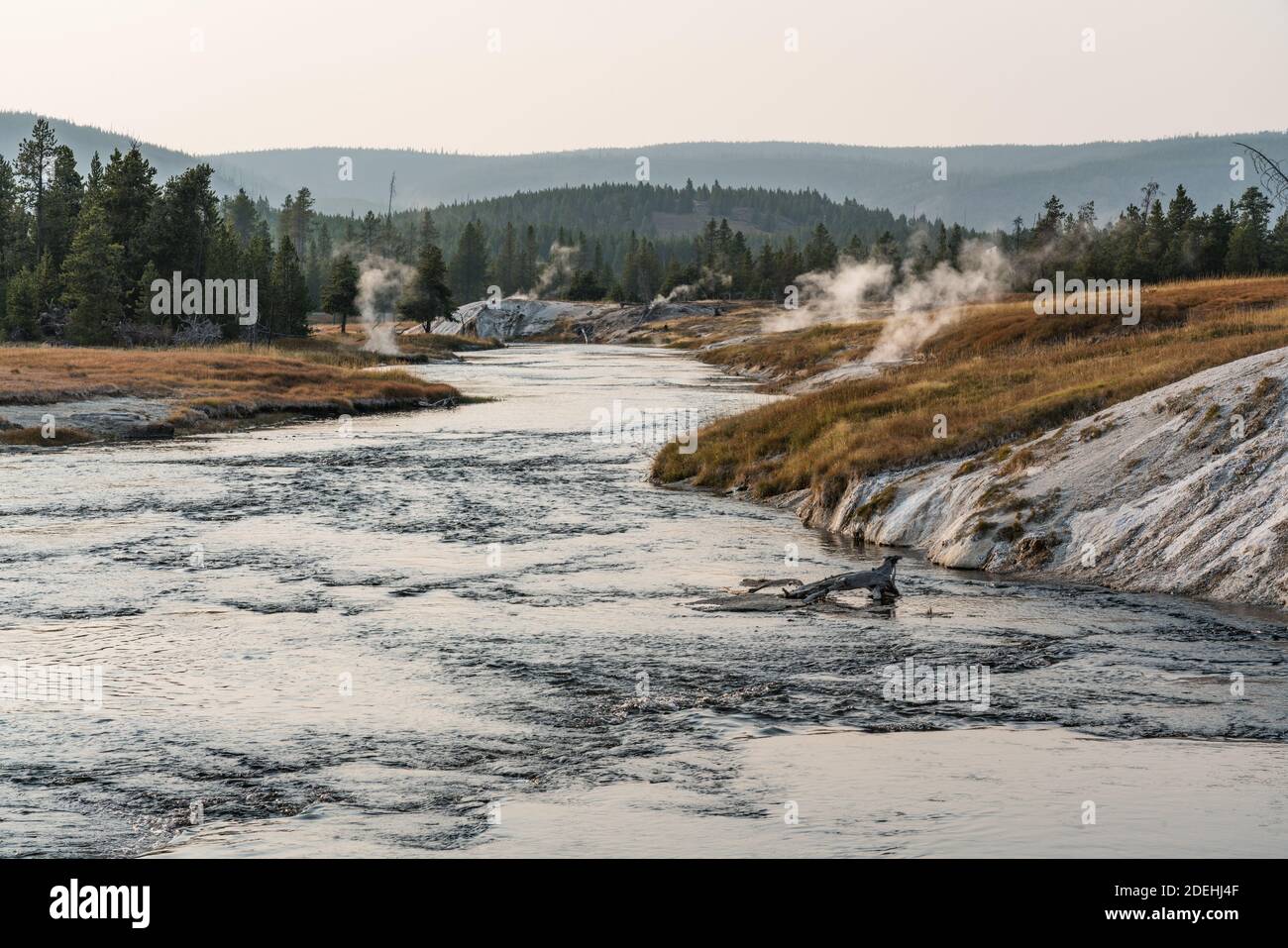 Geysers and hot springs steam along the Firehole River in the Upper ...