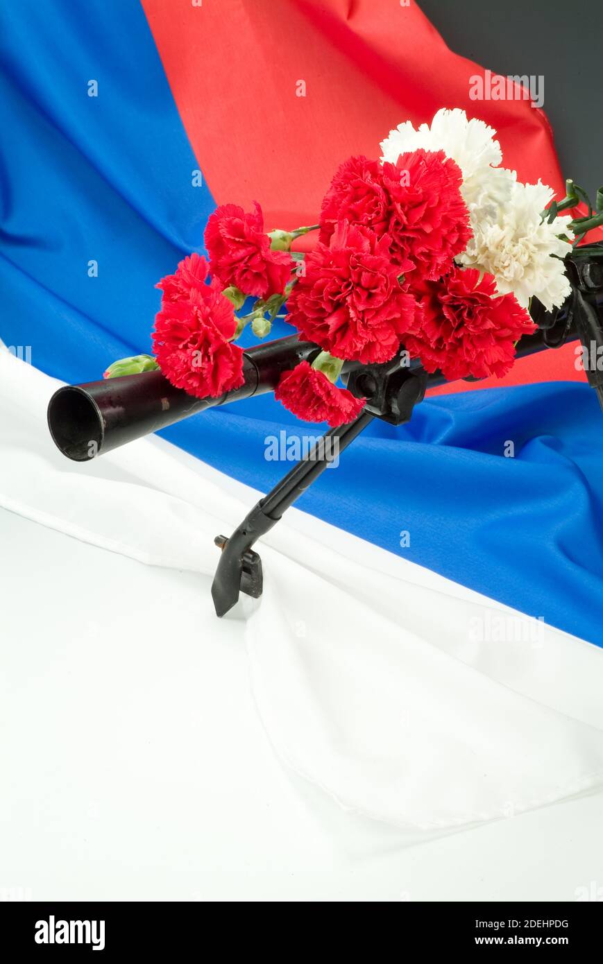 Machine gun and flowers on a studio background Stock Photo - Alamy