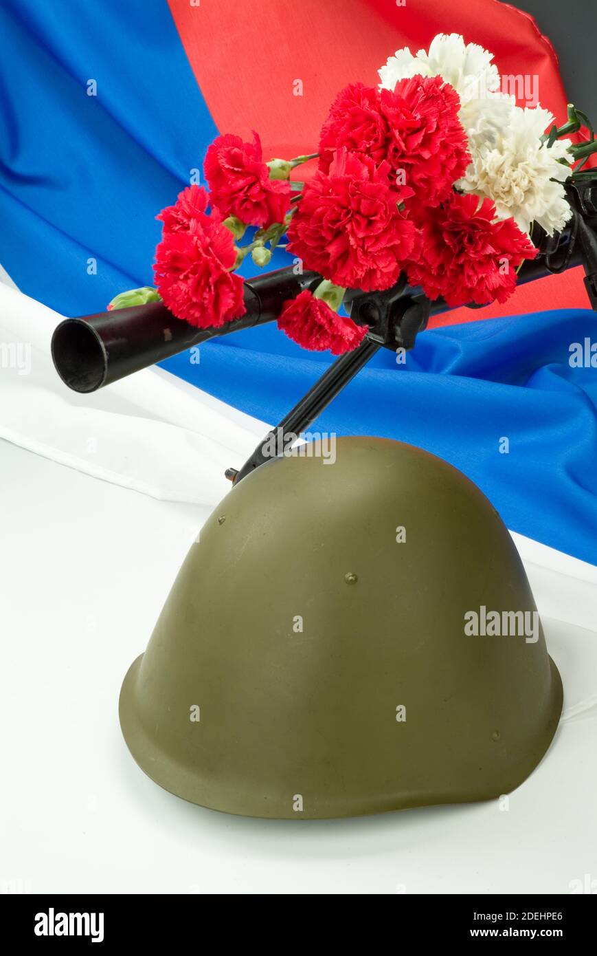 Machine gun and flowers on a studio background Stock Photo - Alamy